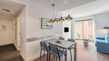 Cozinha moderna com mesa de jantar, cadeiras e iluminação pendente.