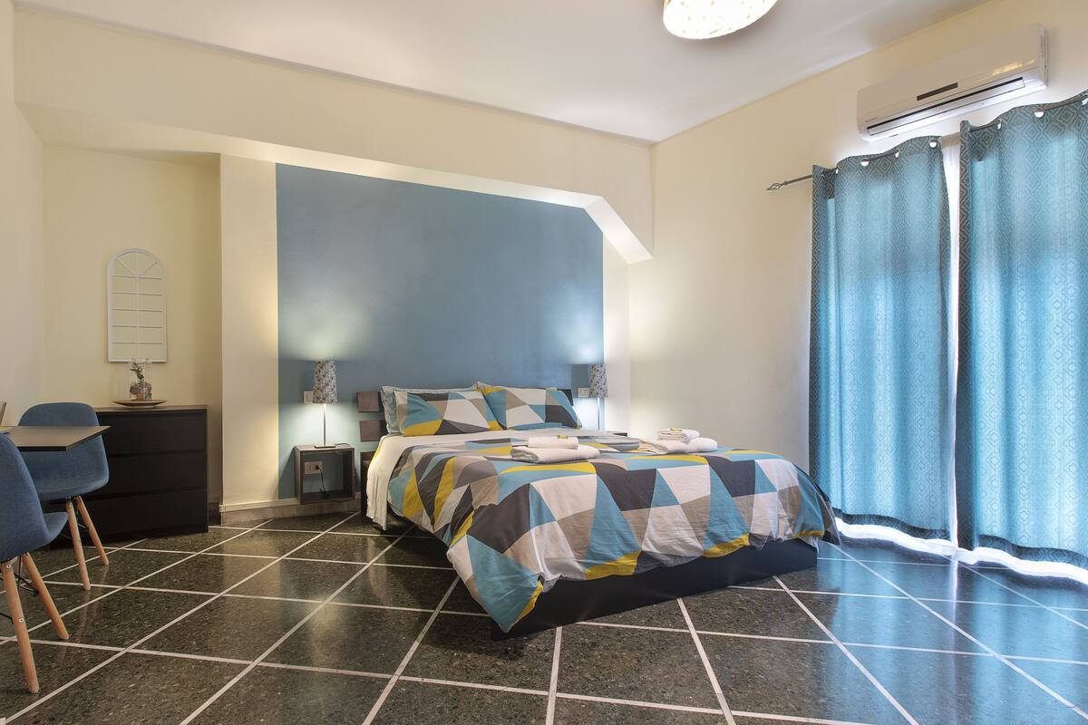 Um quarto com uma cama, uma escrivaninha e uma cadeira.