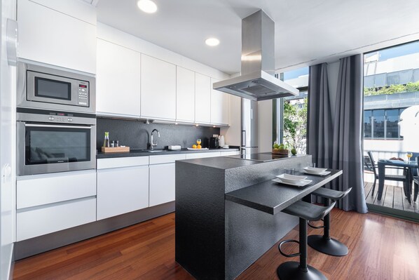 Penthouse, vista para o pátio | Cozinha privada | Um frigorífico/congelador grande, um micro-ondas, um forno 