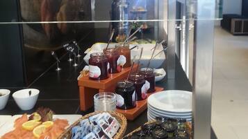 Buffet com diversos alimentos, incluindo salmão defumado, pão e acompanhamentos.