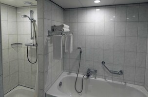 Uma casa de banho moderna com chuveiro, banheira e sanita.