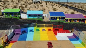 Um parquinho com área de recreação colorida e um veículo vermelho estacionado perto.