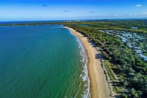 Na praia, praia de areia branca, espreguiçadeiras, toalhas de praia 