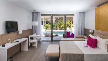 Quarto de hotel com cama, escrivaninha, cadeira, televisão e vista para uma piscina e palmeiras.