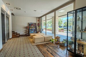 Um interior moderno com escada, estante, área de estar e vitrine de vidro.