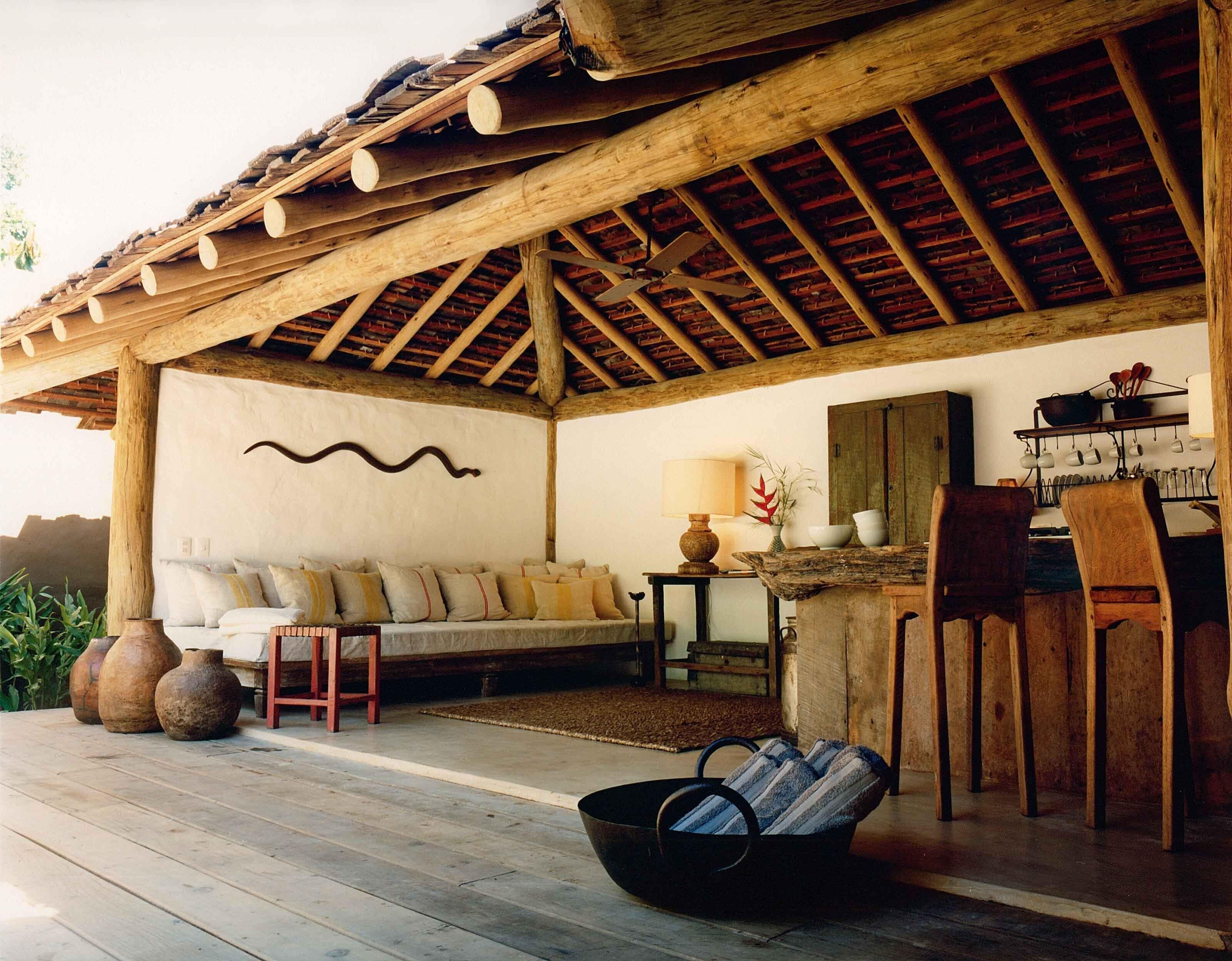 Um quarto rústico de madeira com um sofá, uma mesa e uma cadeira.