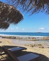 Na praia, praia de areia negra, espreguiçadeiras, guarda-sóis de praia 