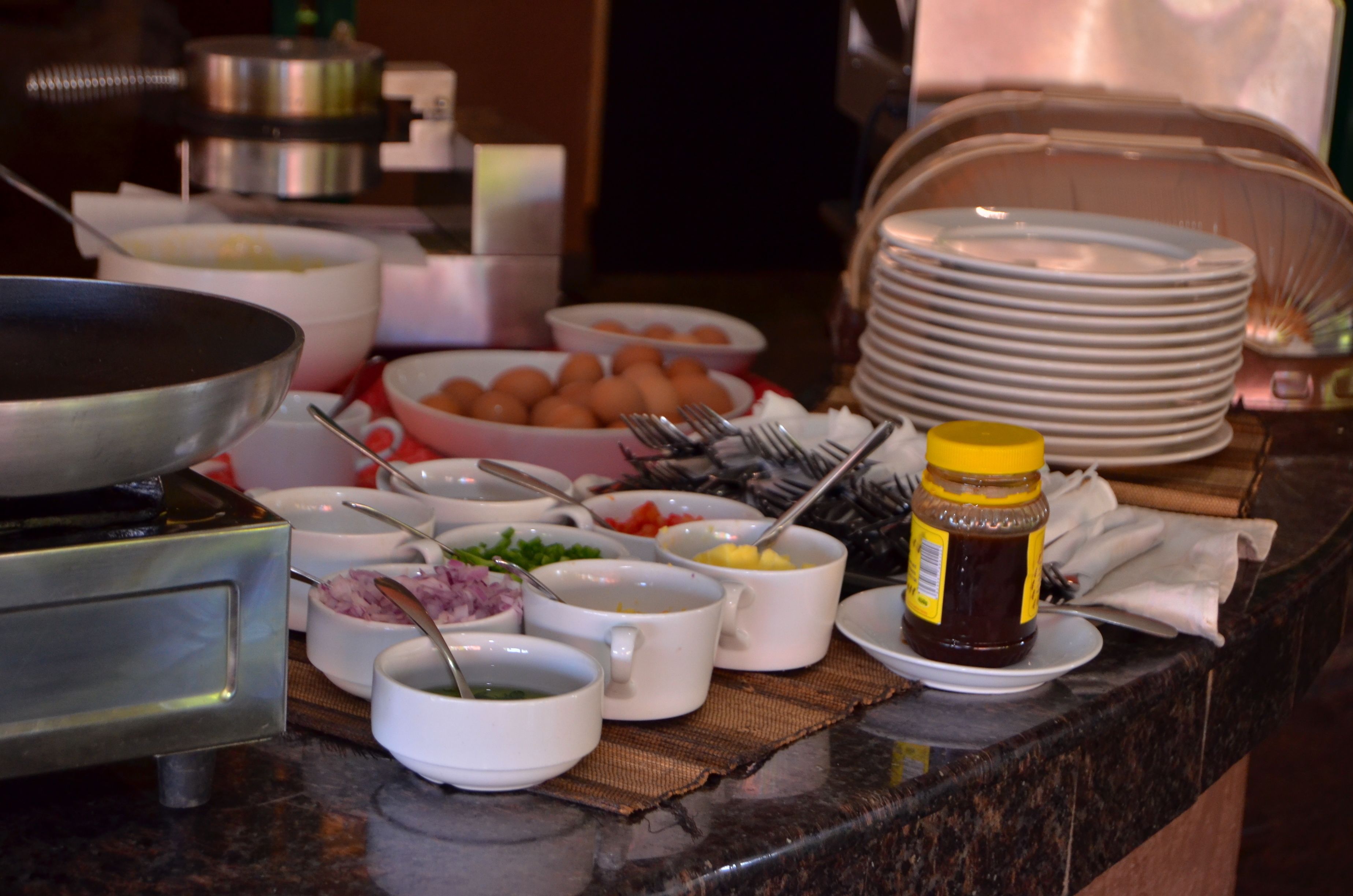 Disposição de buffet com diversos alimentos e utensílios.