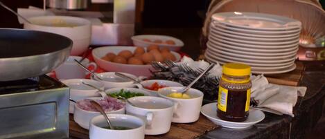 Disposição de buffet com diversos alimentos e utensílios.