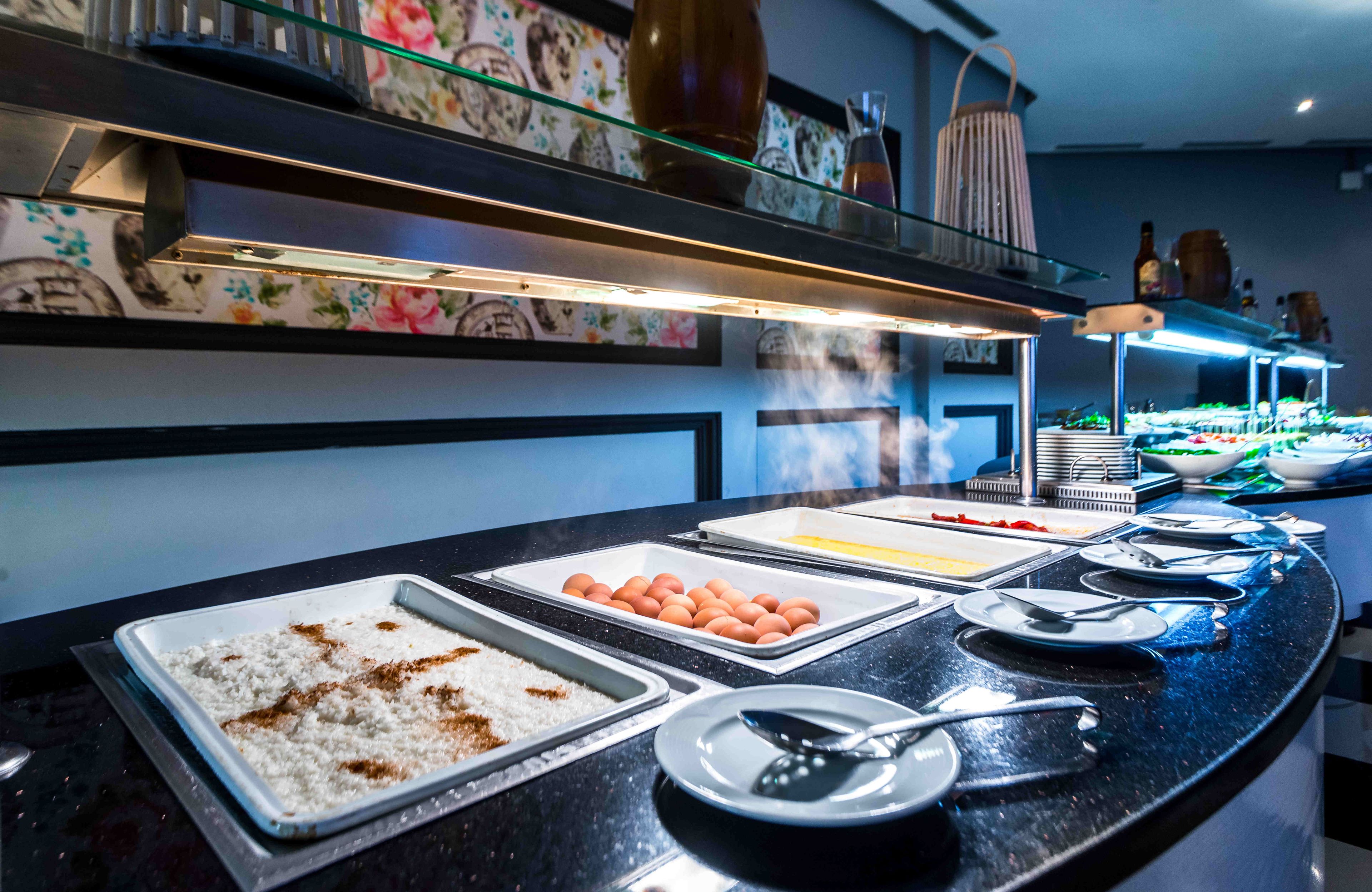Uma mesa de buffet com diversos alimentos e utensílios.
