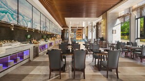 Um restaurante moderno com um balcão extenso, várias áreas de estar e um teto decorativo.