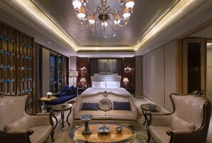 Um quarto luxuoso com uma cama grande, um candelabro e mobiliário ricamente decorado.