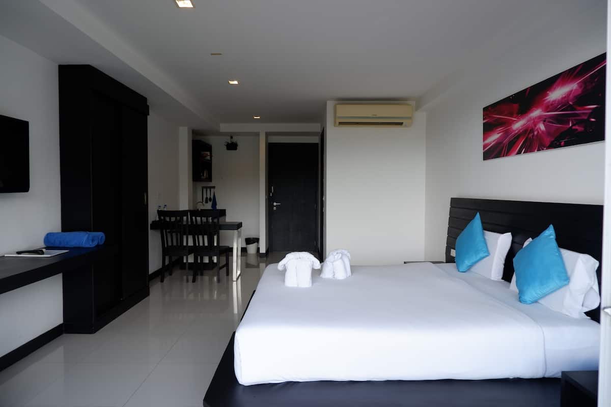Quarto de hotel com uma cama, uma mesa de escritório, uma cadeira e uma mesa de jantar.