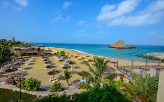 Praia particular, espreguiçadeiras, guarda-sóis