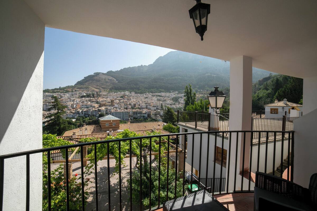 Uma varanda com vista para uma cidade e montanhas.