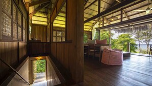 Interior em madeira com escada que leva a uma varanda.