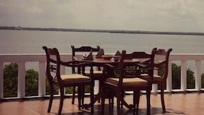 Terraço com mesa e cadeiras com vista para um corpo de água.