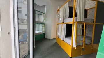 Quarto com beliches, porta deslizante e vista para o exterior.