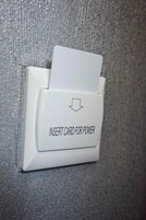 Uma entrada para cartão branco com uma seta apontando para baixo e o texto "INSERT CARD FOR POWER".