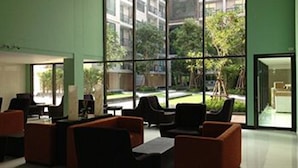 Um lobby moderno com grandes janelas, área de estar e vista para o exterior.