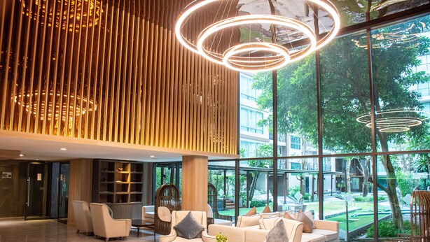 Um lobby moderno com área de estar, grandes janelas e um painel de madeira ripa.