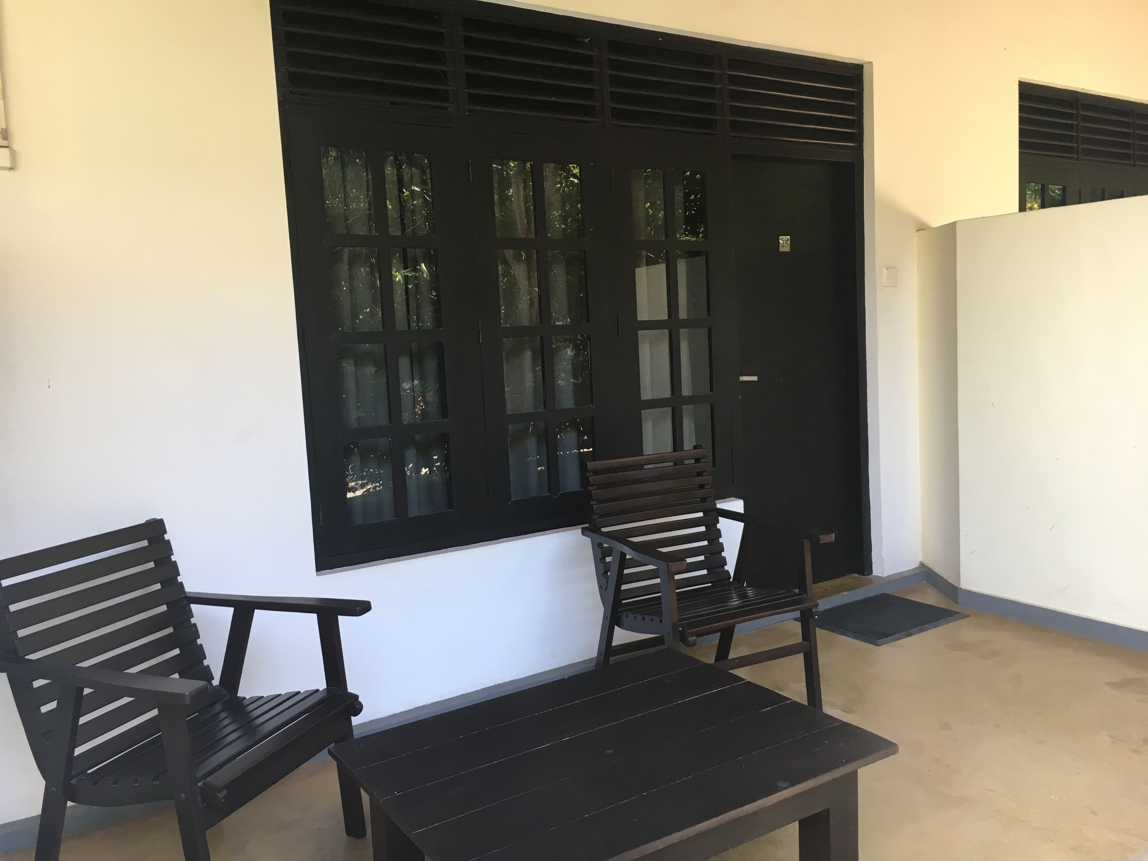 Um quarto com uma janela de moldura preta, um banco preto e uma mesa preta.