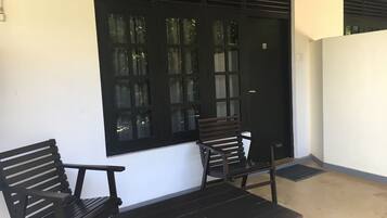 Um quarto com uma janela de moldura preta, um banco preto e uma mesa preta.