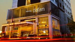 Um hotel moderno com design vertical marcante, grandes janelas e entrada bem iluminada.