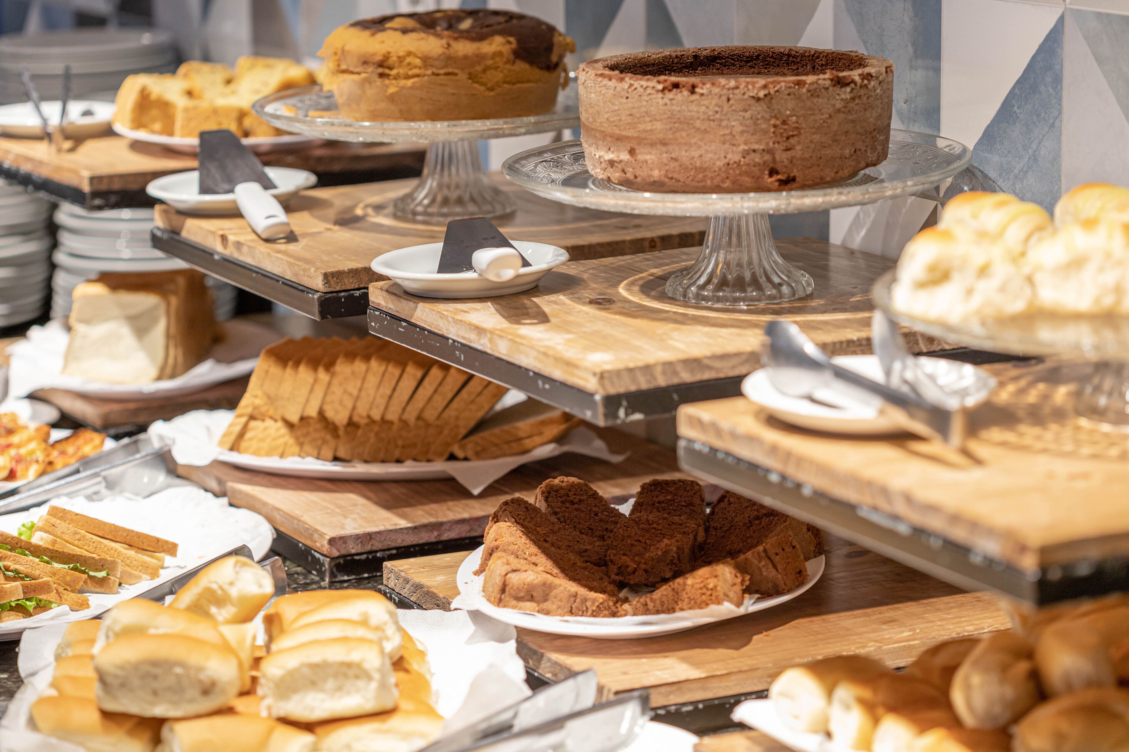 Buffet com diversos bolos e doces à mostra.