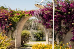 Chuveiro com água caindo em um jardim.