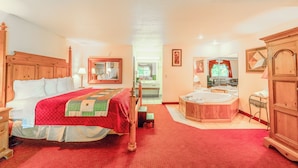 Um quarto espaçoso com uma cama grande, um guarda-roupa de madeira e uma casa de banho separada com banheira.