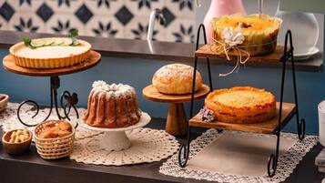 Uma mesa de sobremesas com diversos bolos e doces em suportes.
