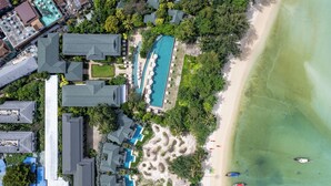 Vista aérea de um resort com piscina, praia e vários edifícios.
