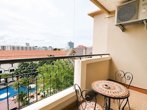 Varanda com vista para uma piscina e edifícios.