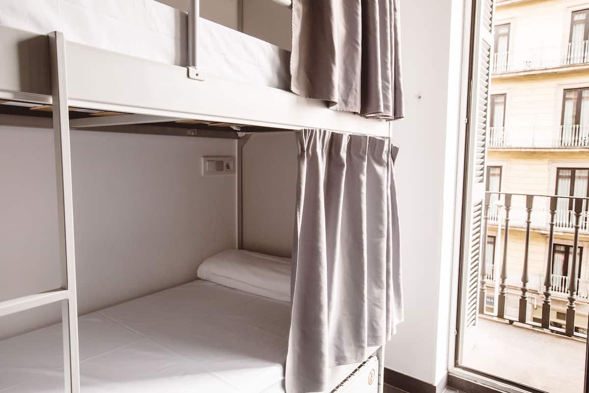 Quarto com beliche e vista para uma varanda.