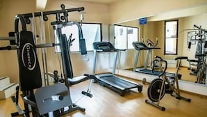 Uma academia com esteiras, bicicleta ergométrica e aparelhos de musculação.