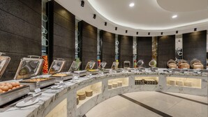 Disposição de buffet com diversos alimentos e utensílios.