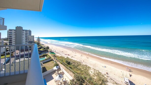 Um hotel à beira-mar com vista para o oceano, piscina e área de varanda com mobiliário para áreas externas.