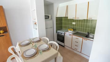 Um frigorífico/congelador grande, um micro-ondas, uma placa de cozinha