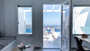Quarto moderno com vista para o mar, sala de jantar com mesa e cadeiras, e um espaço de estar aconchegante.