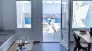 Quarto moderno com varanda e vista panorâmica para o mar e colinas.