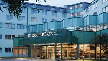 Entrada de um hotel com uma placa indicando 'DOUBLETREE by Hilton'.