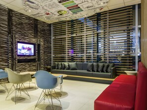 Um interior moderno com televisão, área de estar e uma parede com diversas inscrições.