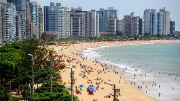 Na praia, guarda-sóis de praia, toalhas de praia