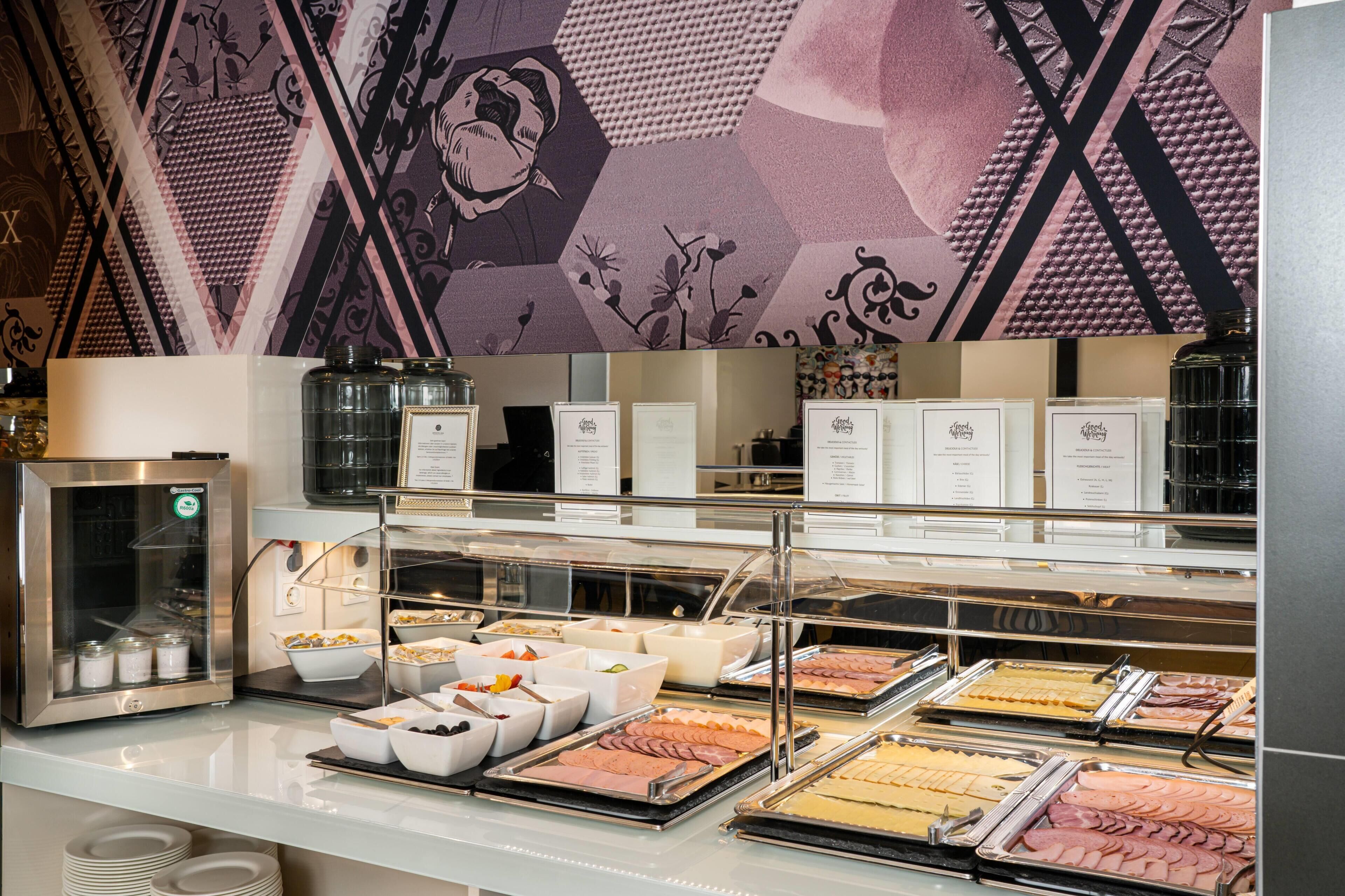 Uma área de buffet com diversos alimentos e um refrigerador expositor.