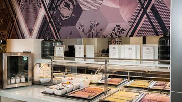 Uma área de buffet com diversos alimentos e um refrigerador expositor.