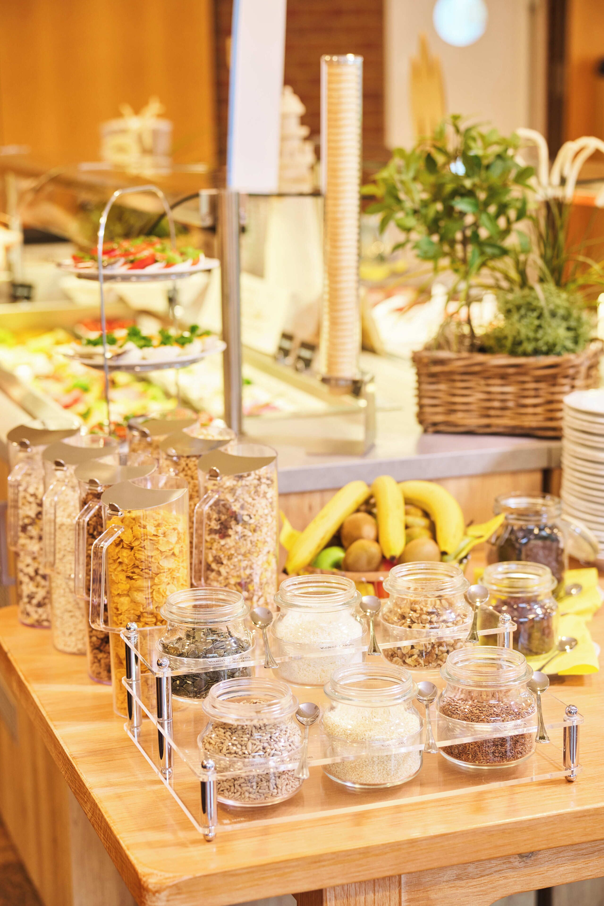 Buffet com diversos alimentos e acompanhamentos em recipientes transparentes.