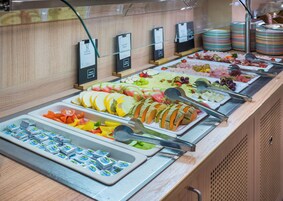 Um buffet com diversos alimentos e utensílios.