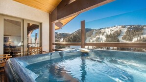Uma banheira de hidromassagem com vista para uma paisagem nevada de montanha.