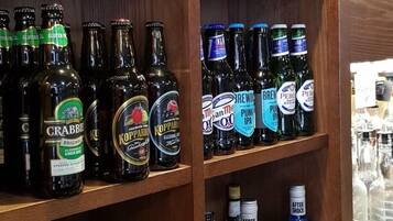 Estante repleta de garrafas de bebidas alcoólicas diversas, incluindo marcas como Sky Black, Sky Gold e After Shock.